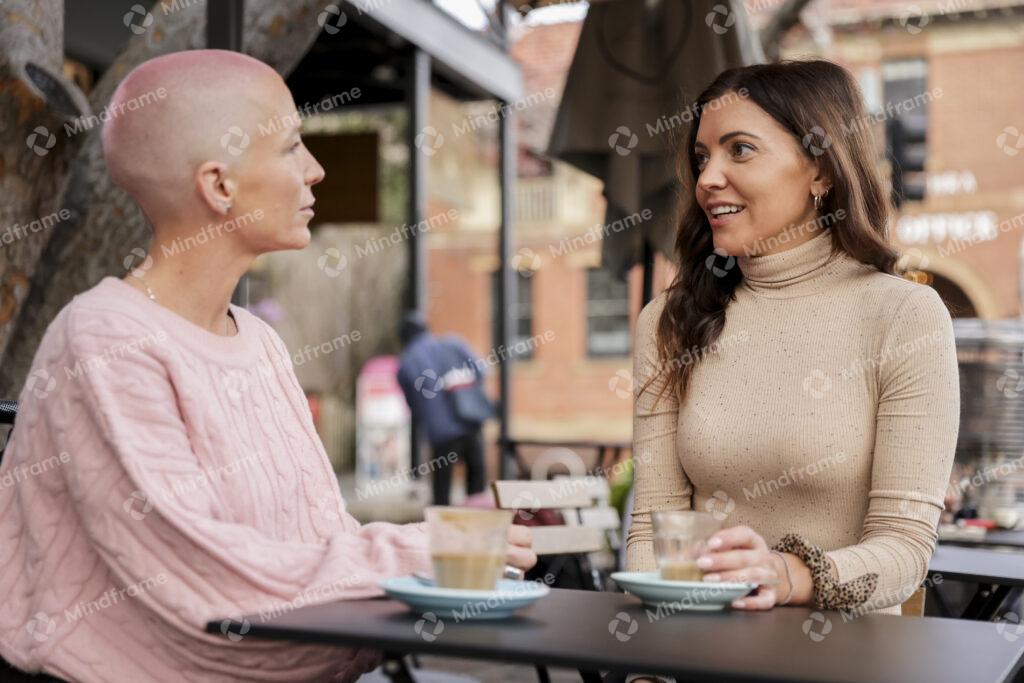 Two people talking, sitting outside at a cafe – Mindframe online image ...