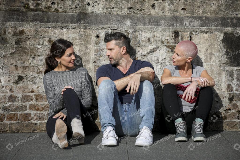 Three people sitting outside talking – Mindframe online image collection