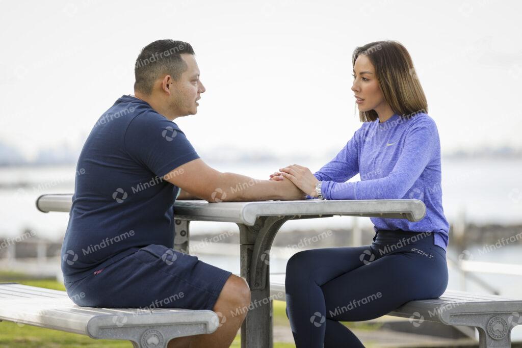 Two people talking at a picnic table – Mindframe online image collection