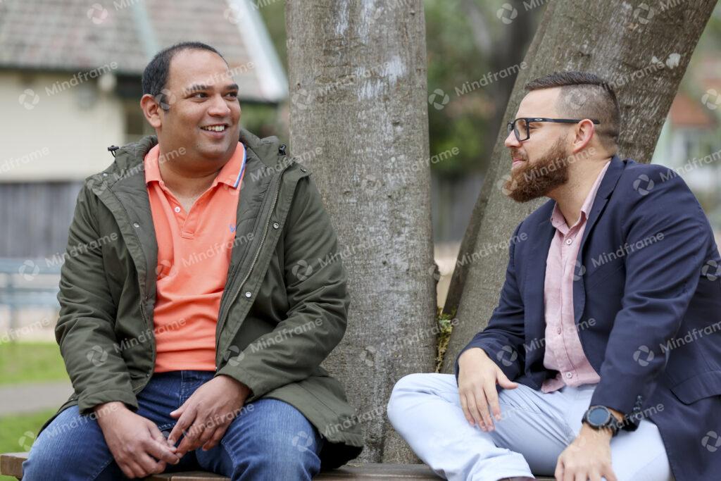 Two people talking and sitting outside in front of tree – Mindframe ...