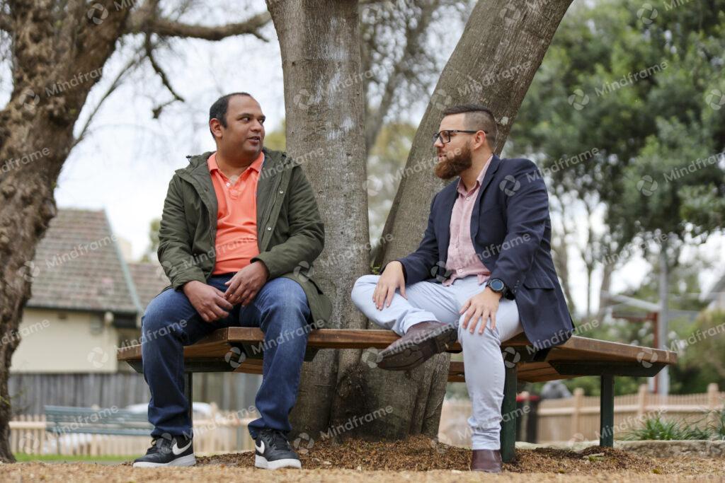 Two people talking and sitting on bench in front of tree – Mindframe ...