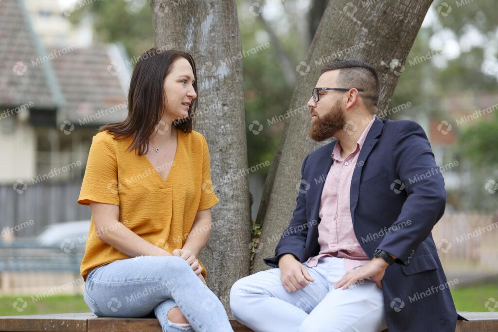 Two people talking and sitting on bench in front of tree – Mindframe ...