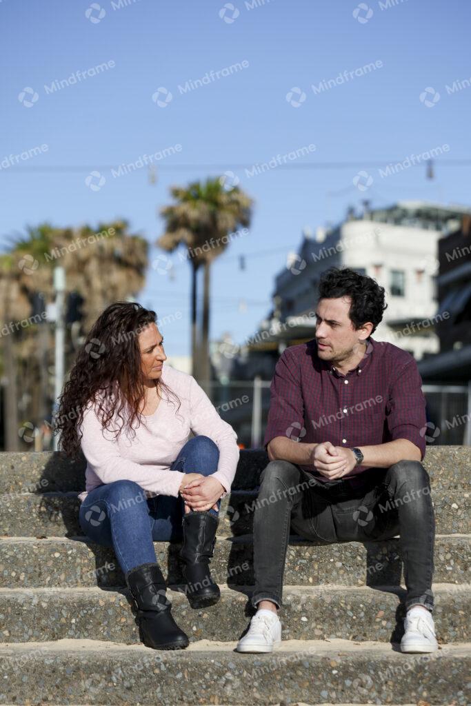 Two people sitting on steps near road – Mindframe online image collection