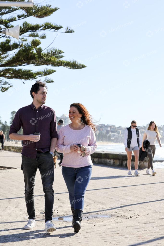 Two people walking and talking with a coffee – Mindframe online image ...