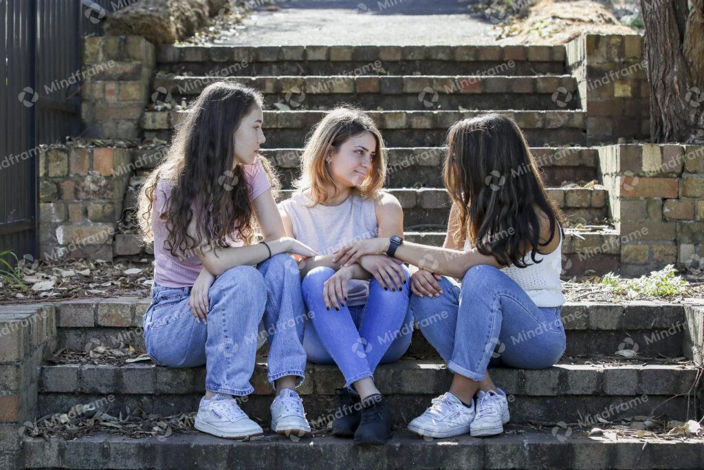 Group of young women sitting outside on steps talking – Mindframe ...