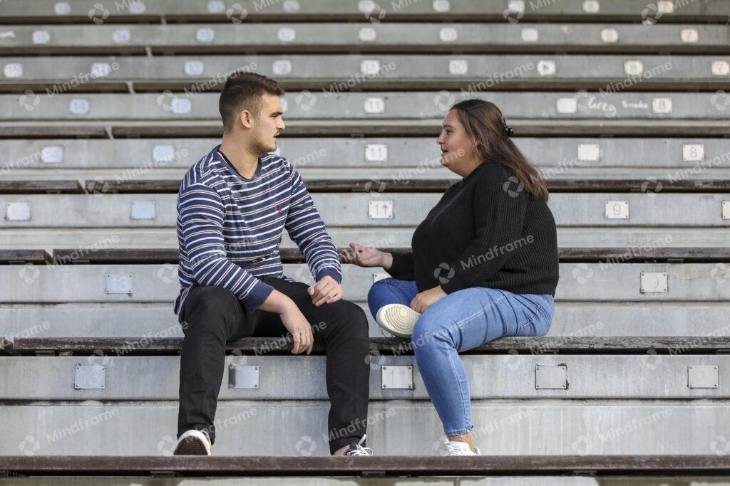 Two people talking outdoors on a bench – Mindframe online image collection