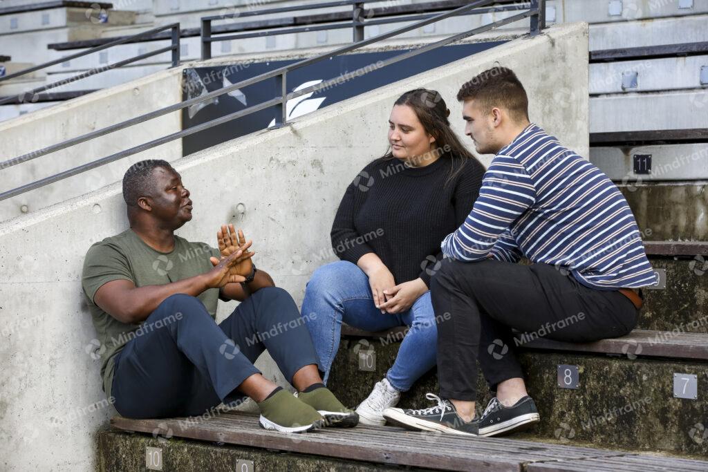 Three people talking sitting on step outside – Mindframe online image ...