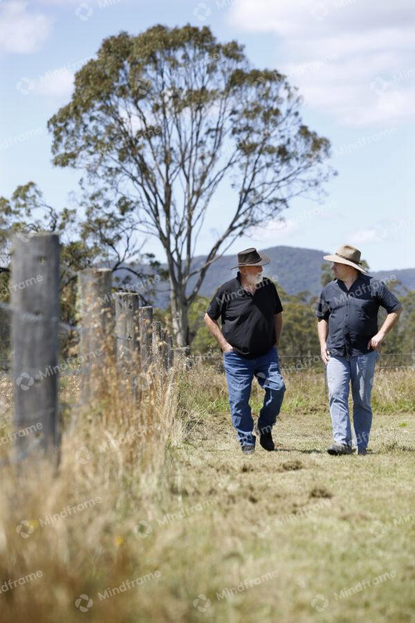 Two people walking by a paddock fence at a farm – Mindframe online ...
