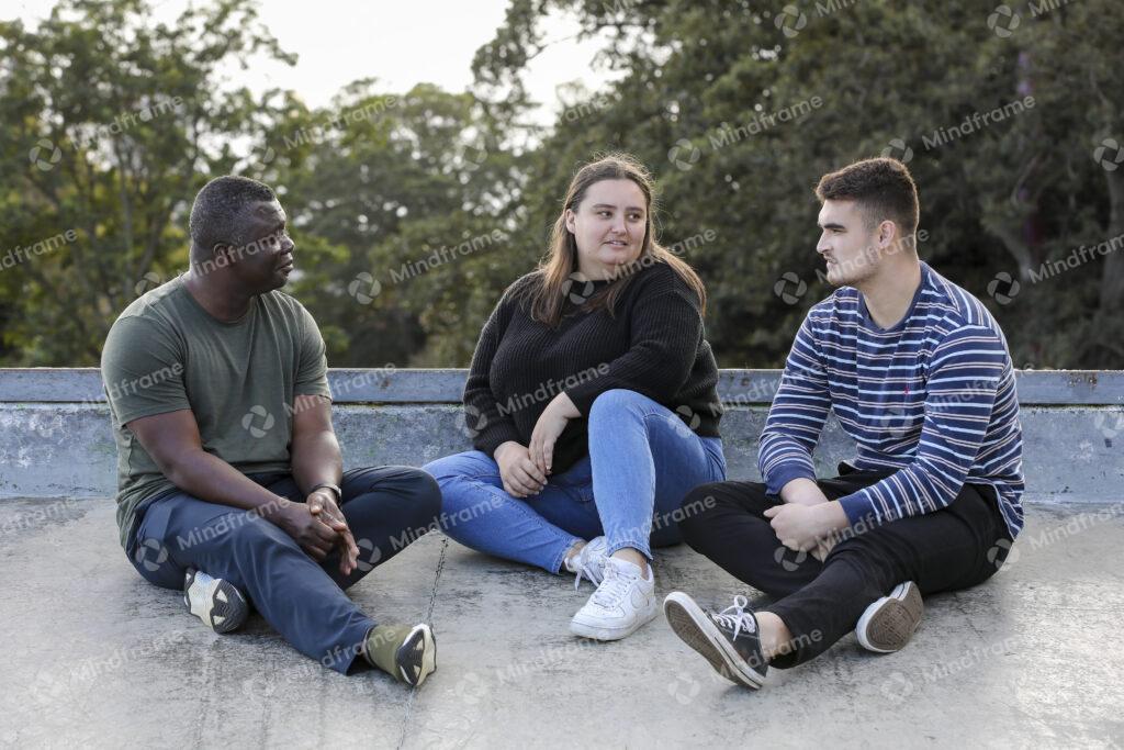 Three people talking,sitting outside – Mindframe online image collection