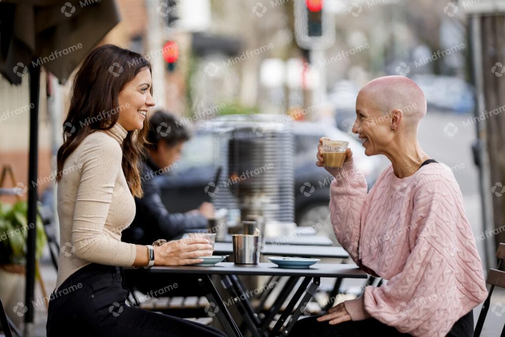 Two people sitting outside talking at a cafe – Mindframe online image ...