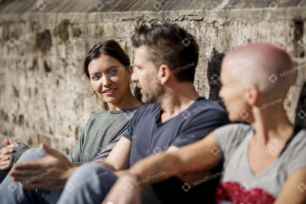 Three people sitting and talking, outside – Mindframe online image ...