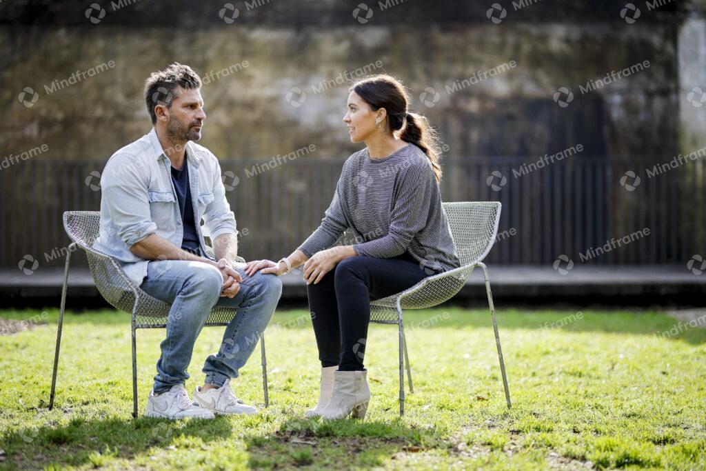 Two people sitting, talking in a garden – Mindframe online image collection